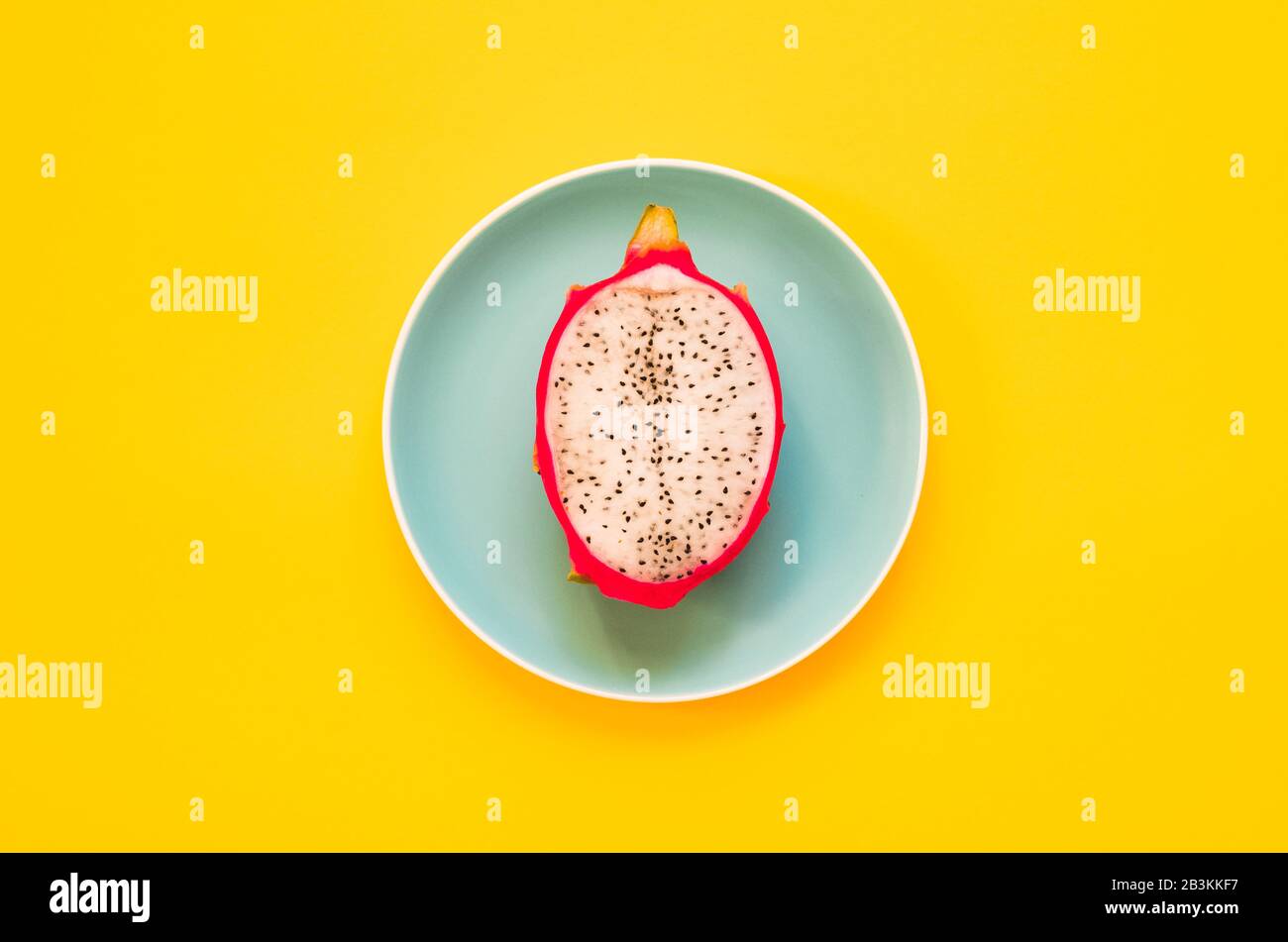 Pitaya. The close-up of ripe cut dragon fruit on blue plate on yellow ...