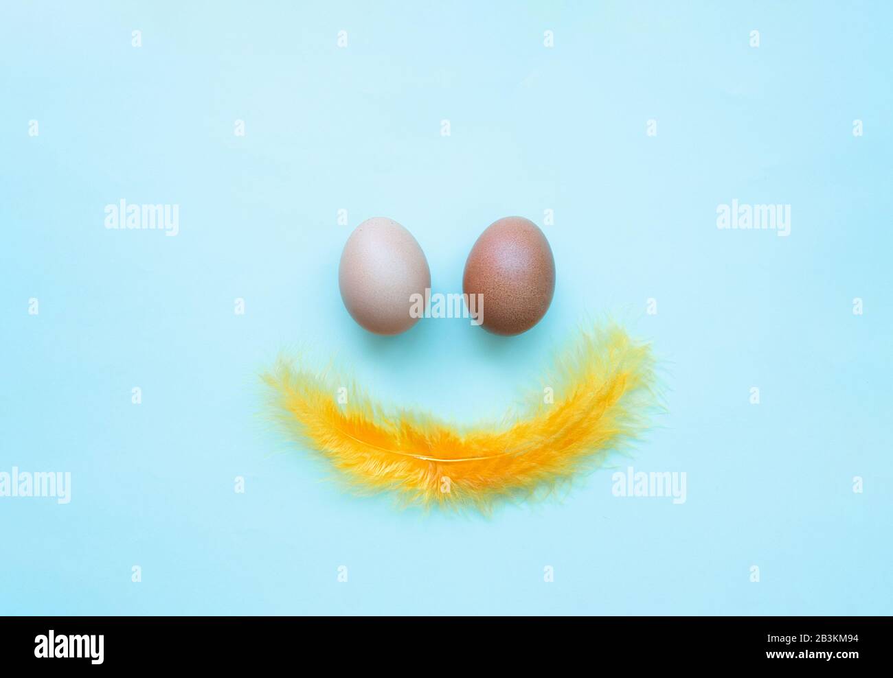 Funny smiling face of two chicken Easter eggs on a clear blue ...
