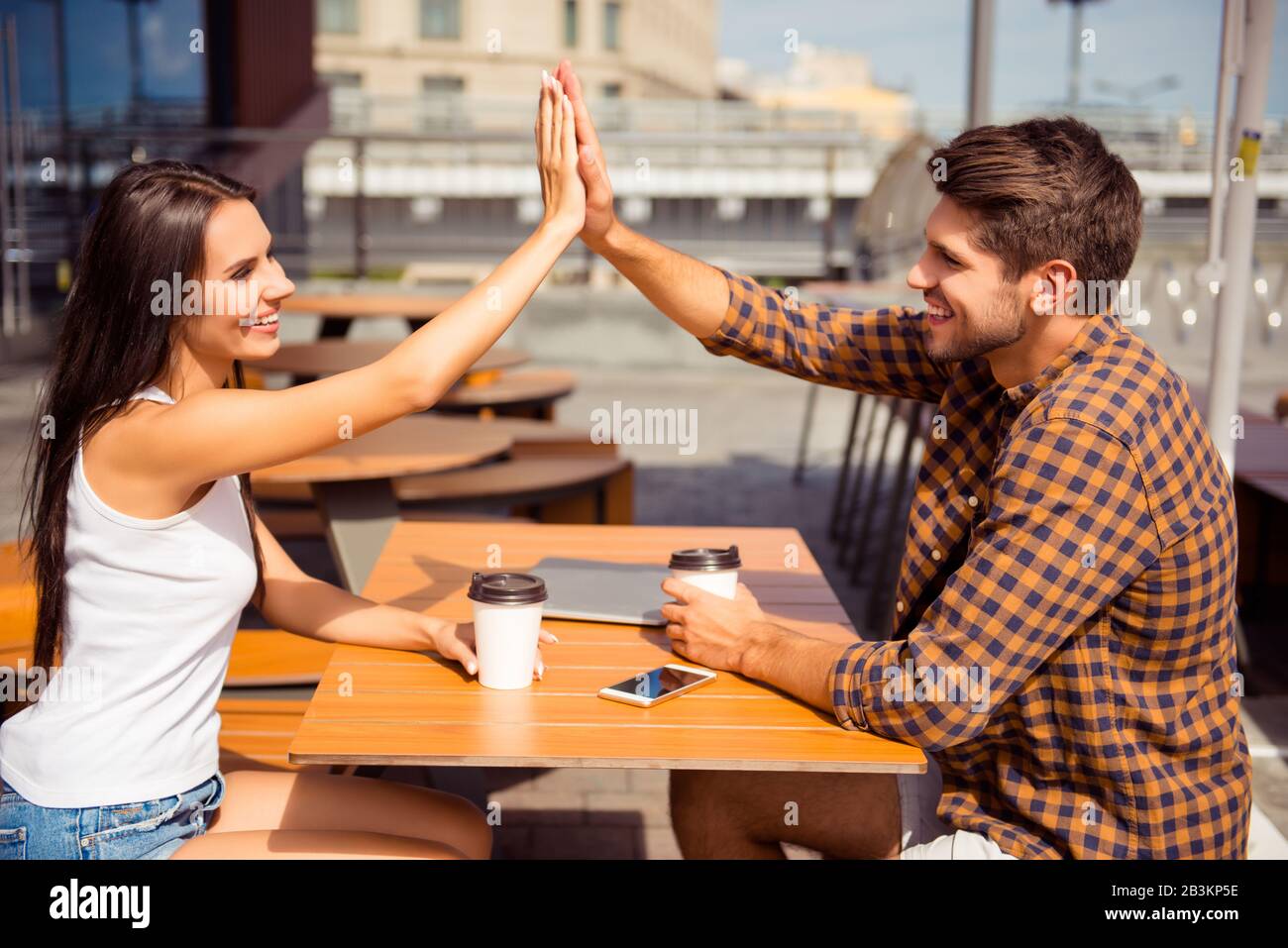 Happy pretty woman giving high five to her boyfriend in cafe Stock ...