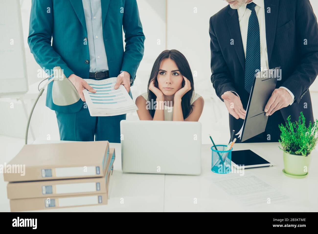Sad tired businesswoman. Her colleagues giving a lot of work to her ...