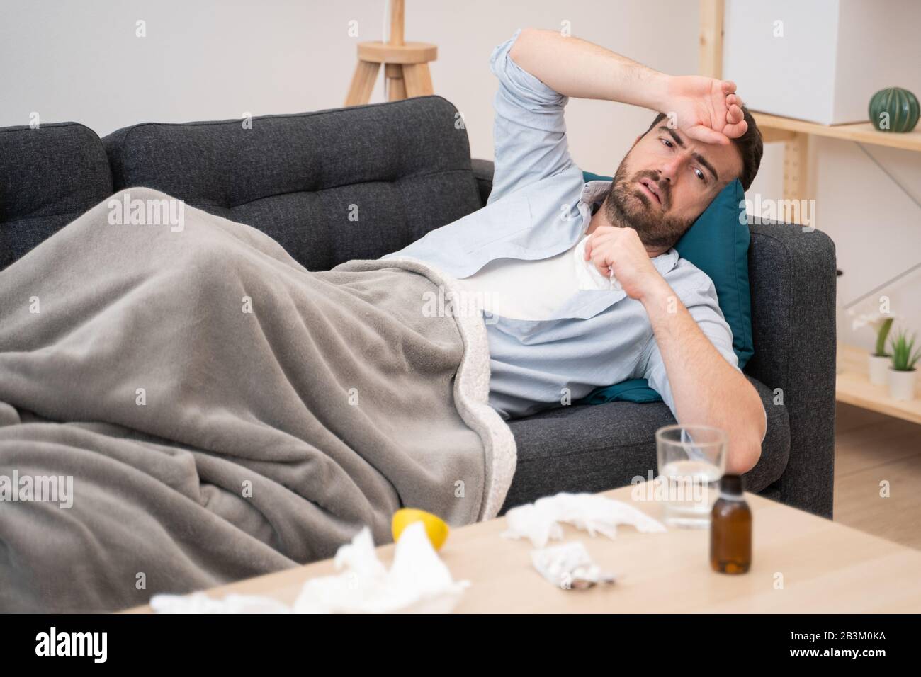 Sick man lying on couch hi-res stock photography and images - Alamy