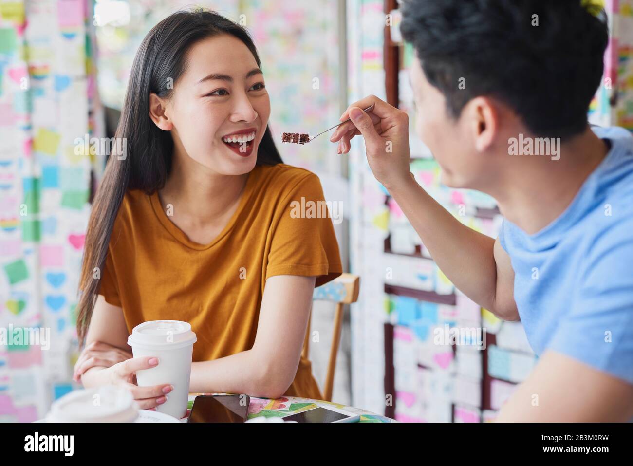 Man feeding woman dessert on a date Stock Photo - Alamy