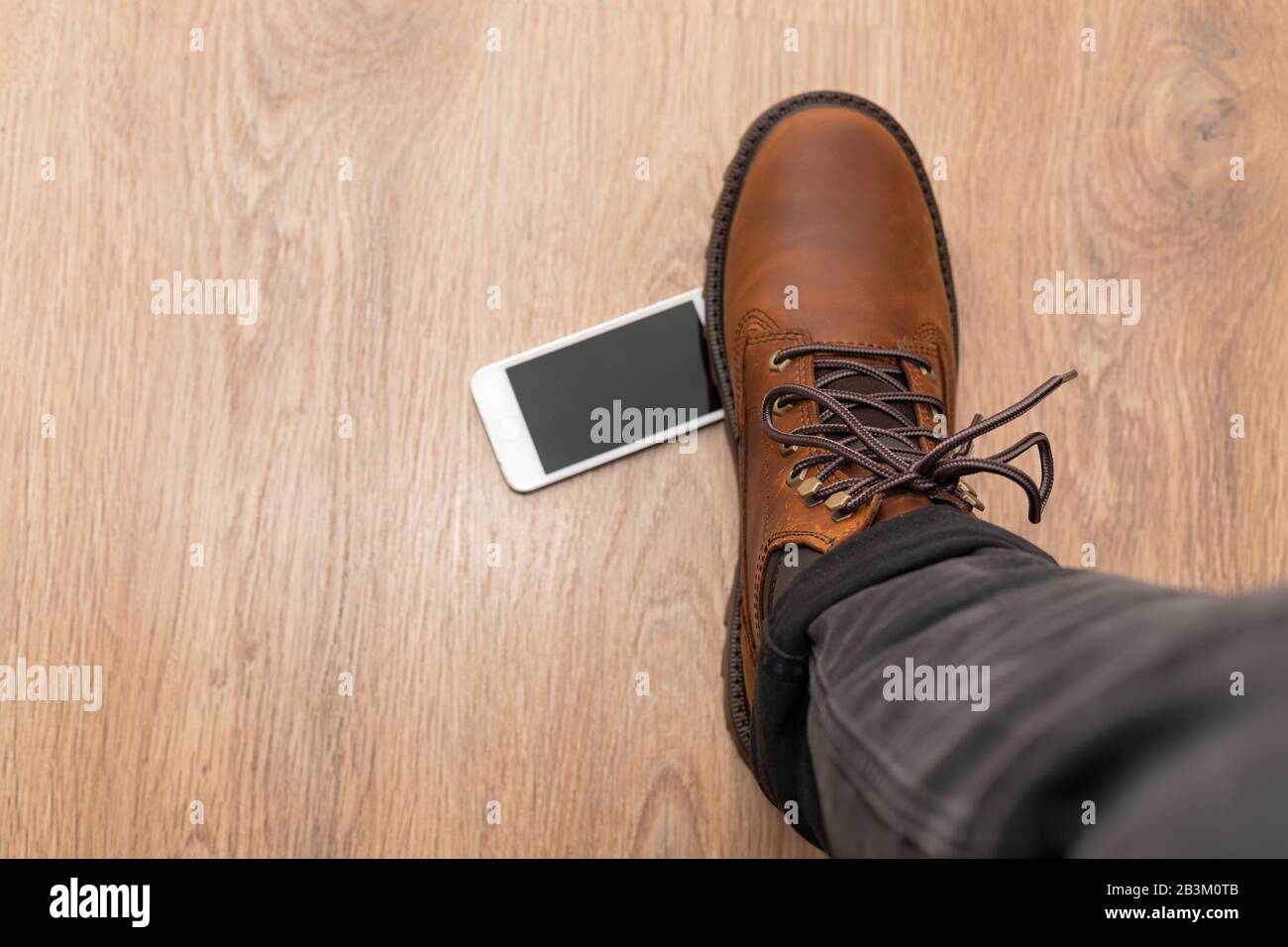 Picture of a men's boot steps on a smartphone Stock Photo - Alamy