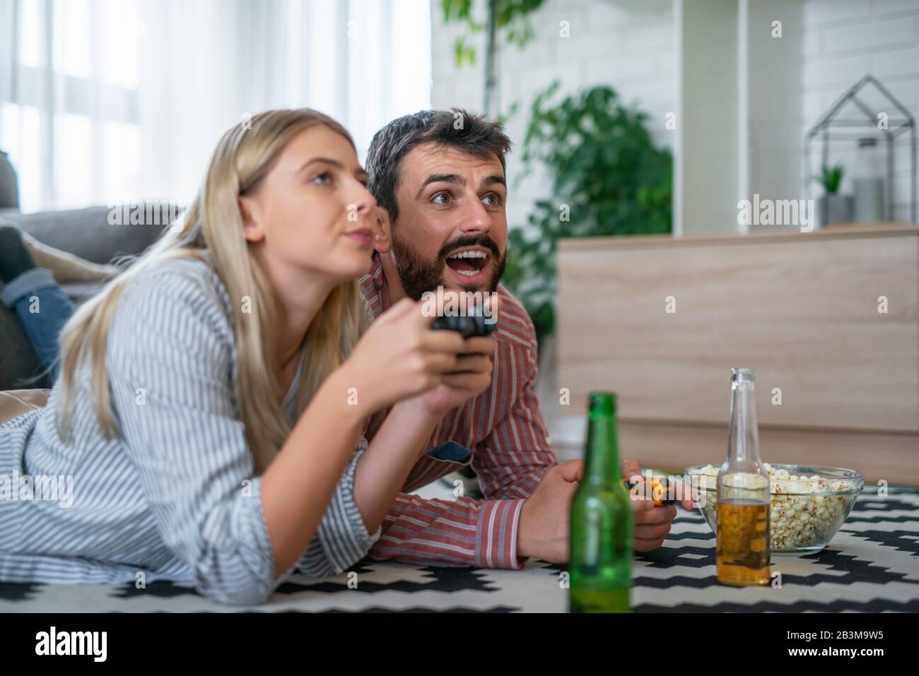 Happy friends playing video games at home.Couple playing video games ...