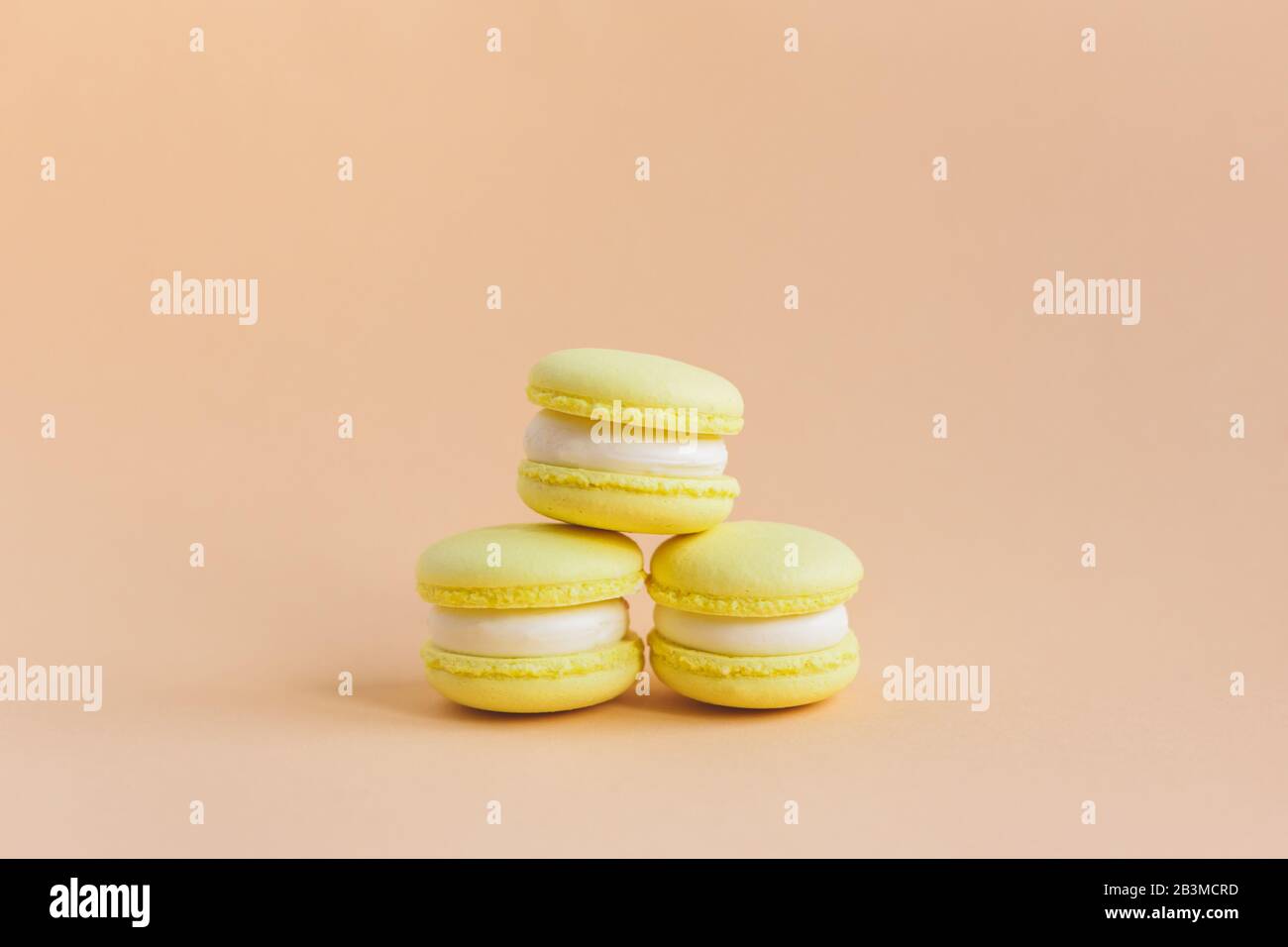 Yellow macarons on a peach pastel background. Lemon macarons. Place for ...