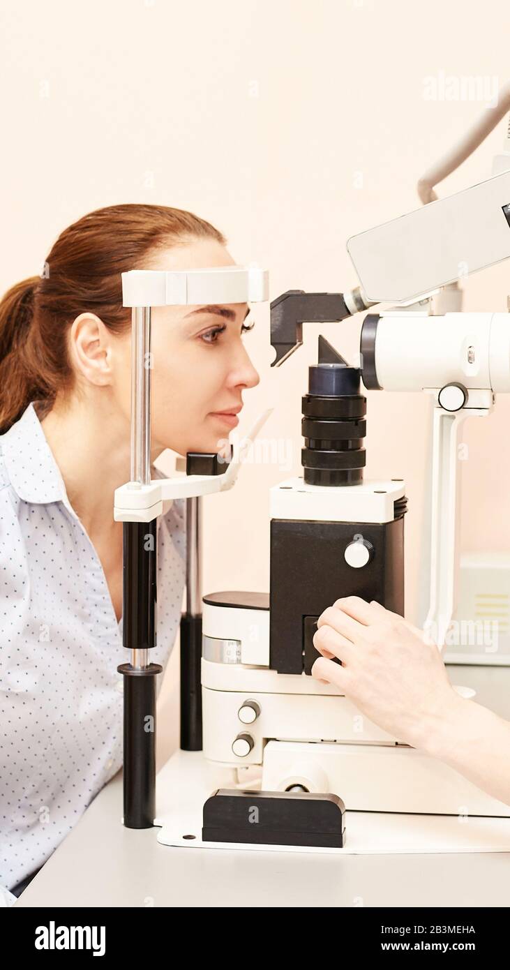 ophthalmologist doctor in exam optician laboratory with female patient ...