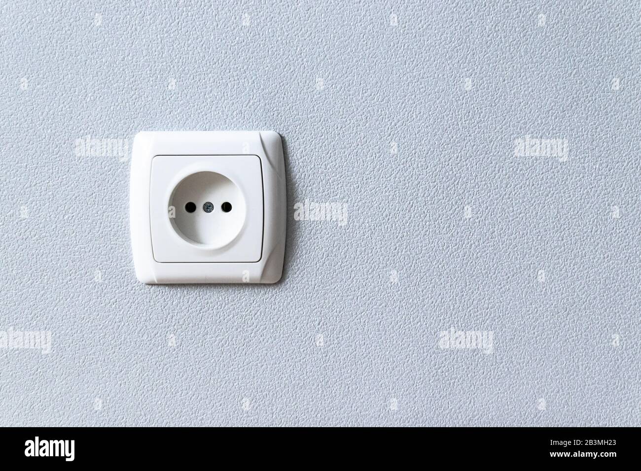 White plastic empty electrical sockets on gray wall with copyspace ...