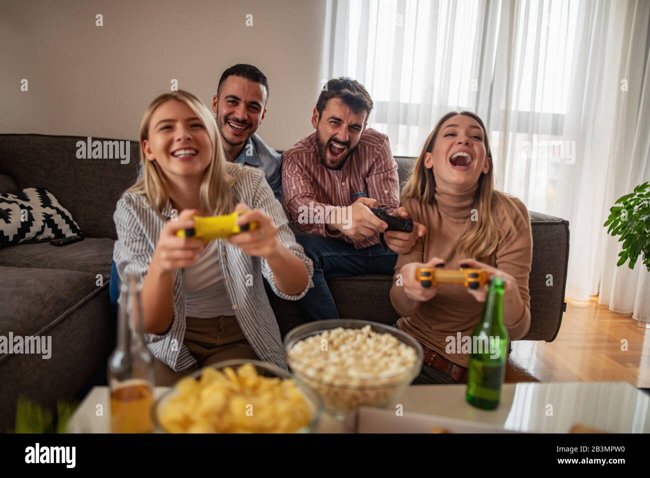 Happy friends playing video games at home.Happiness and gaming concept ...