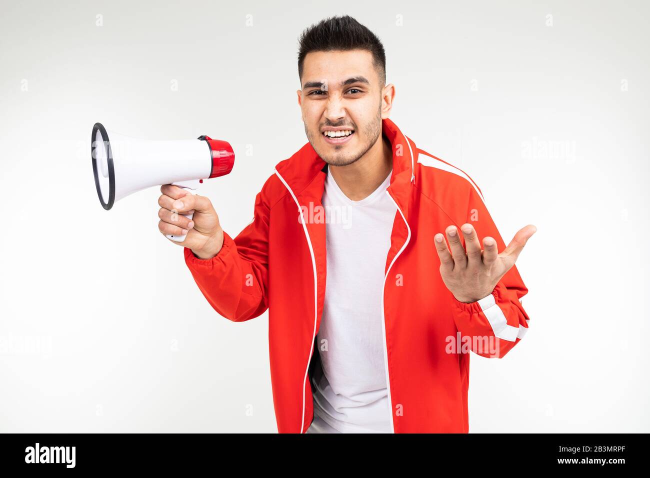 portrait of a young man with a loudspeaker in his hands on a white ...