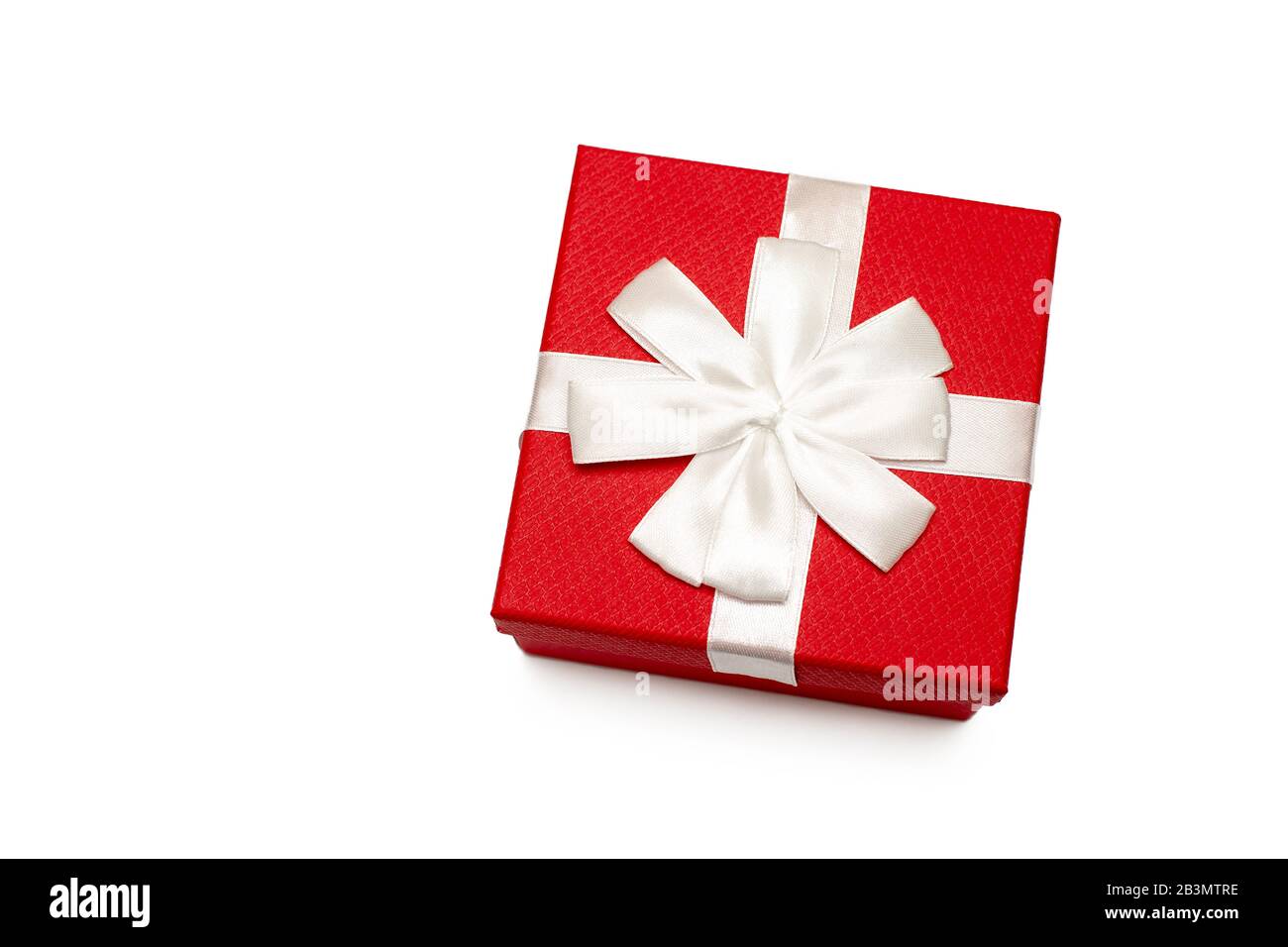 Square red gift box with a white bow on a white background. Copy space ...