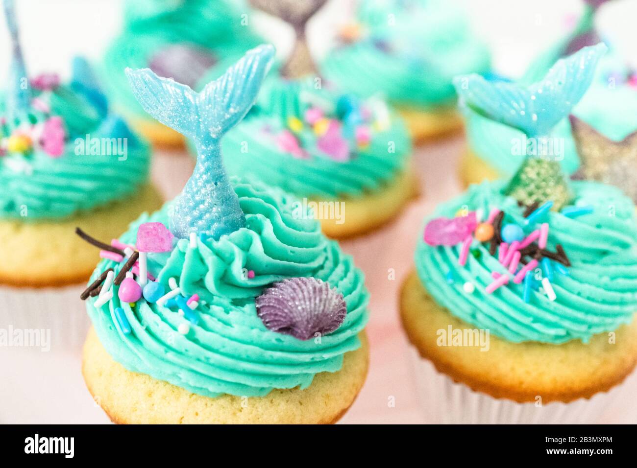 Gourmet mermaid cupcakes topped with blue buttercream frosting and ...