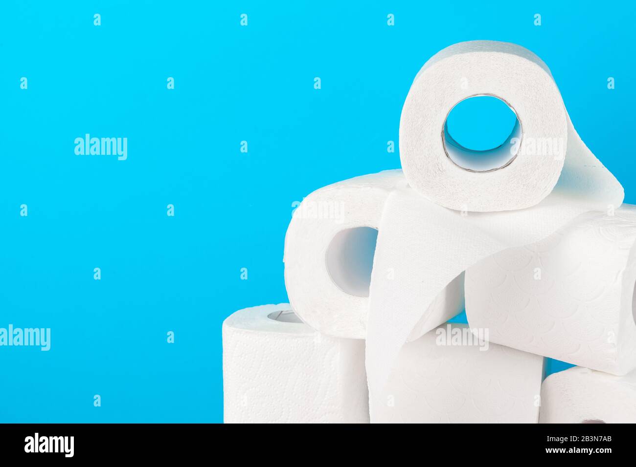 Toilet paper stack on bright blue background Stock Photo - Alamy