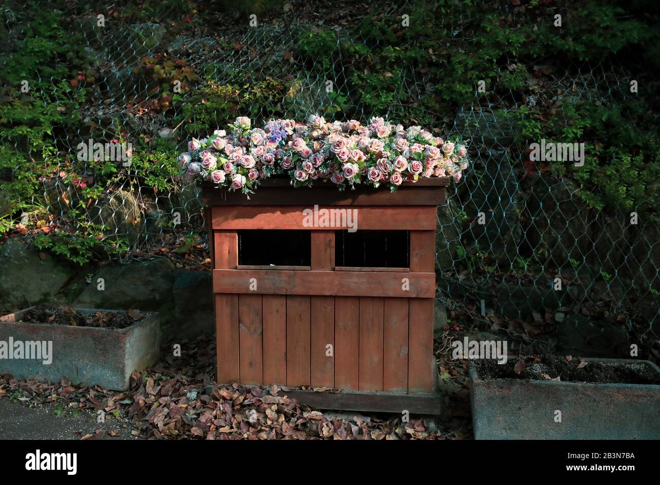 Unique wooden trash bin with flower decoration Stock Photo - Alamy