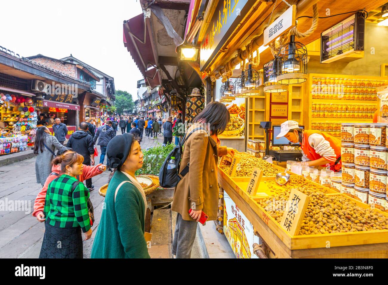 Busy shopping street and local food on display in Ciqikou Old Town ...