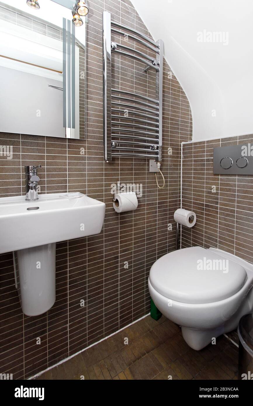 Small toilet interior with brown marble tiles Stock Photo - Alamy