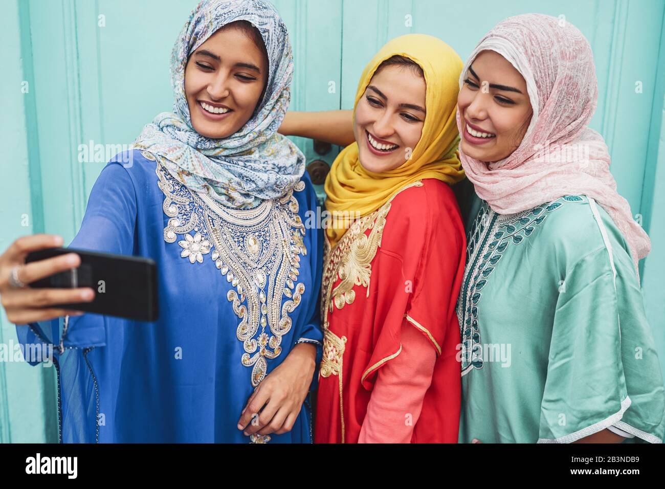 Happy Muslim girls taking selfie with mobile smartphone camera outdoor ...