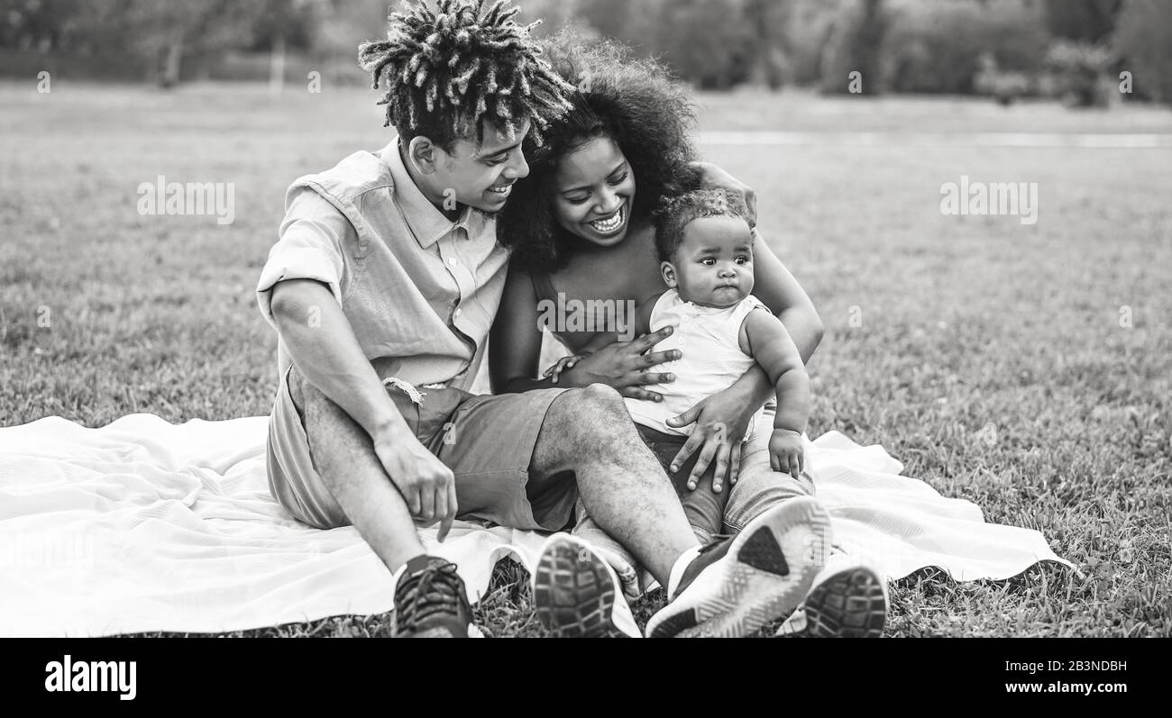 Happy African family having fun during the weekend in public park ...