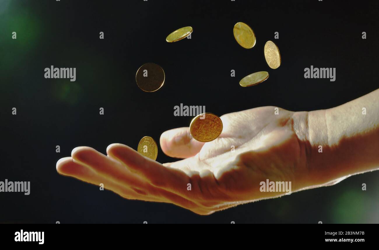 coin floating on human hand in black background Stock Photo - Alamy