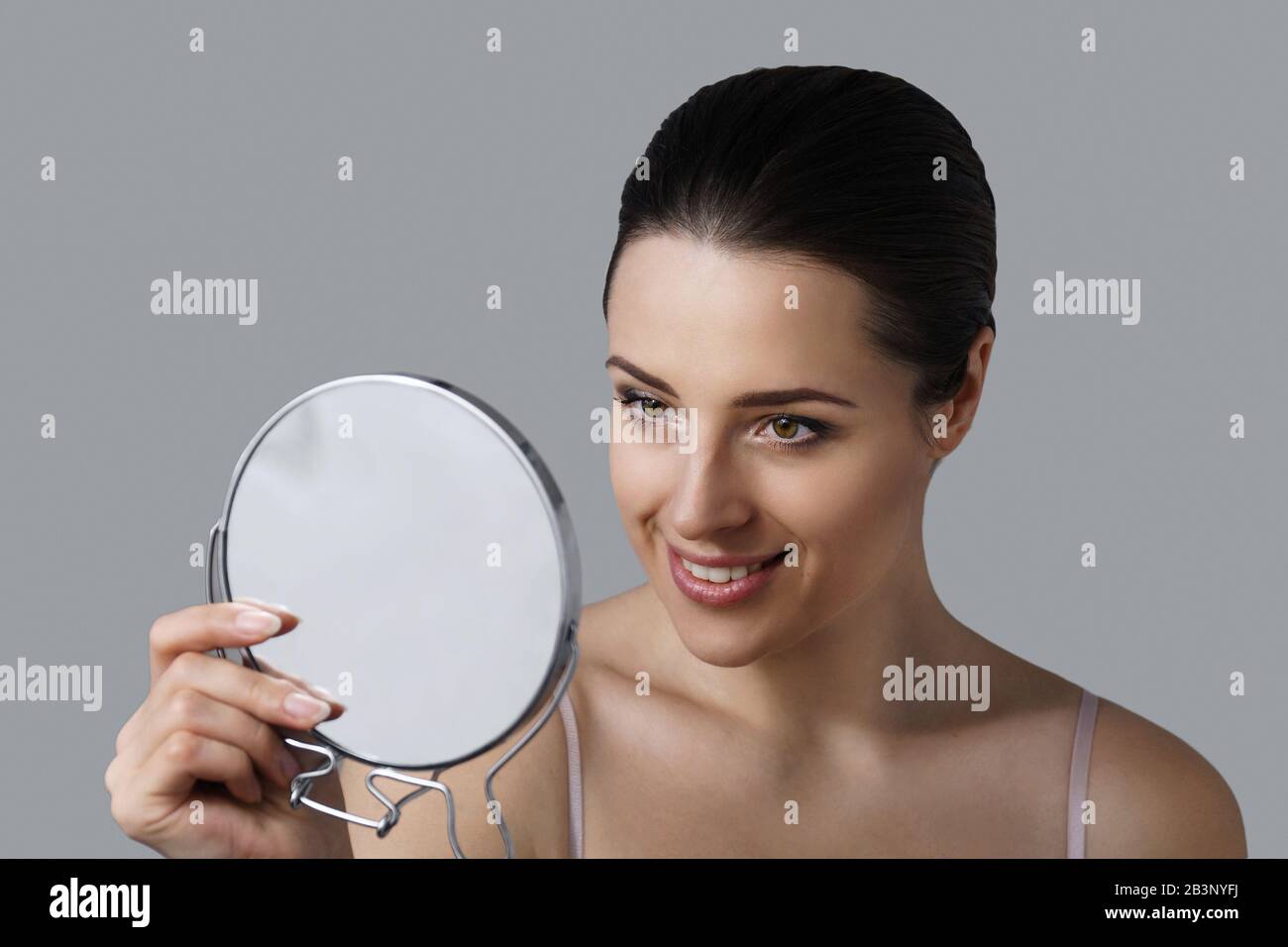 Girl looking in mirror enjoying her makeup with sincere smile Stock ...