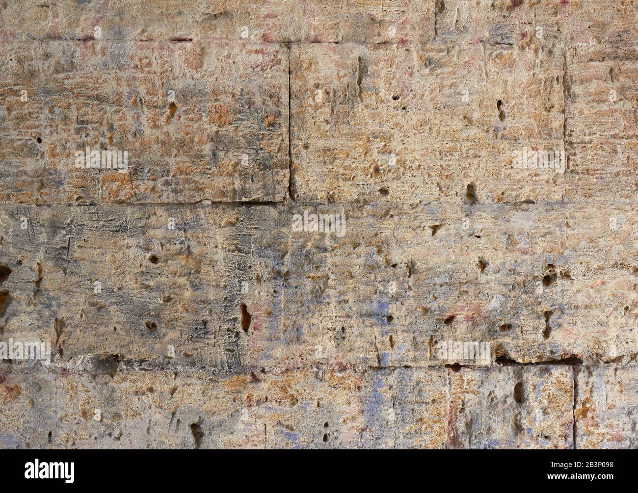 wall of yellow rectangular stones with cement, fragment of ancient ...