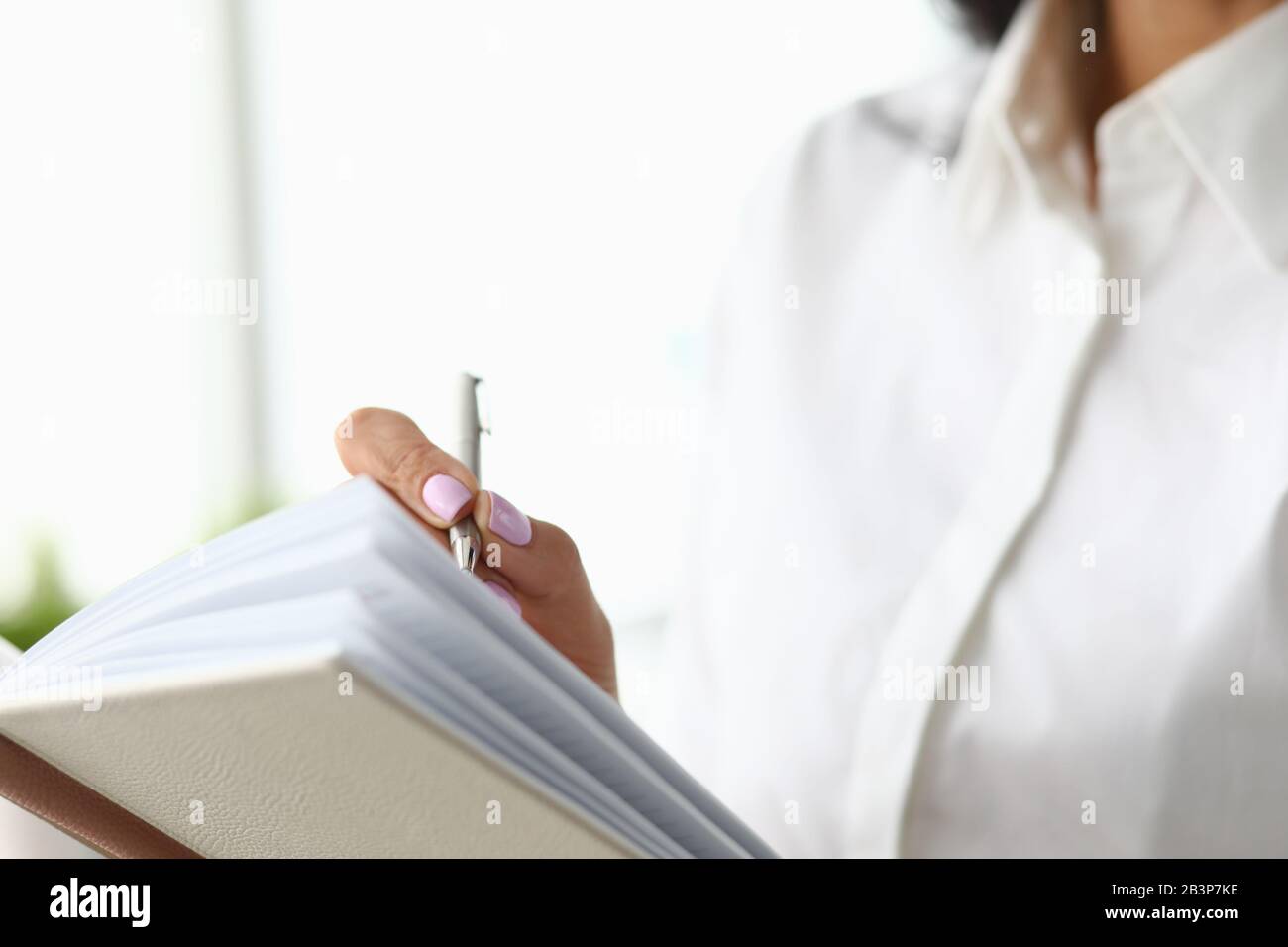 Close-up woman makes notes by pen in notebook Stock Photo - Alamy