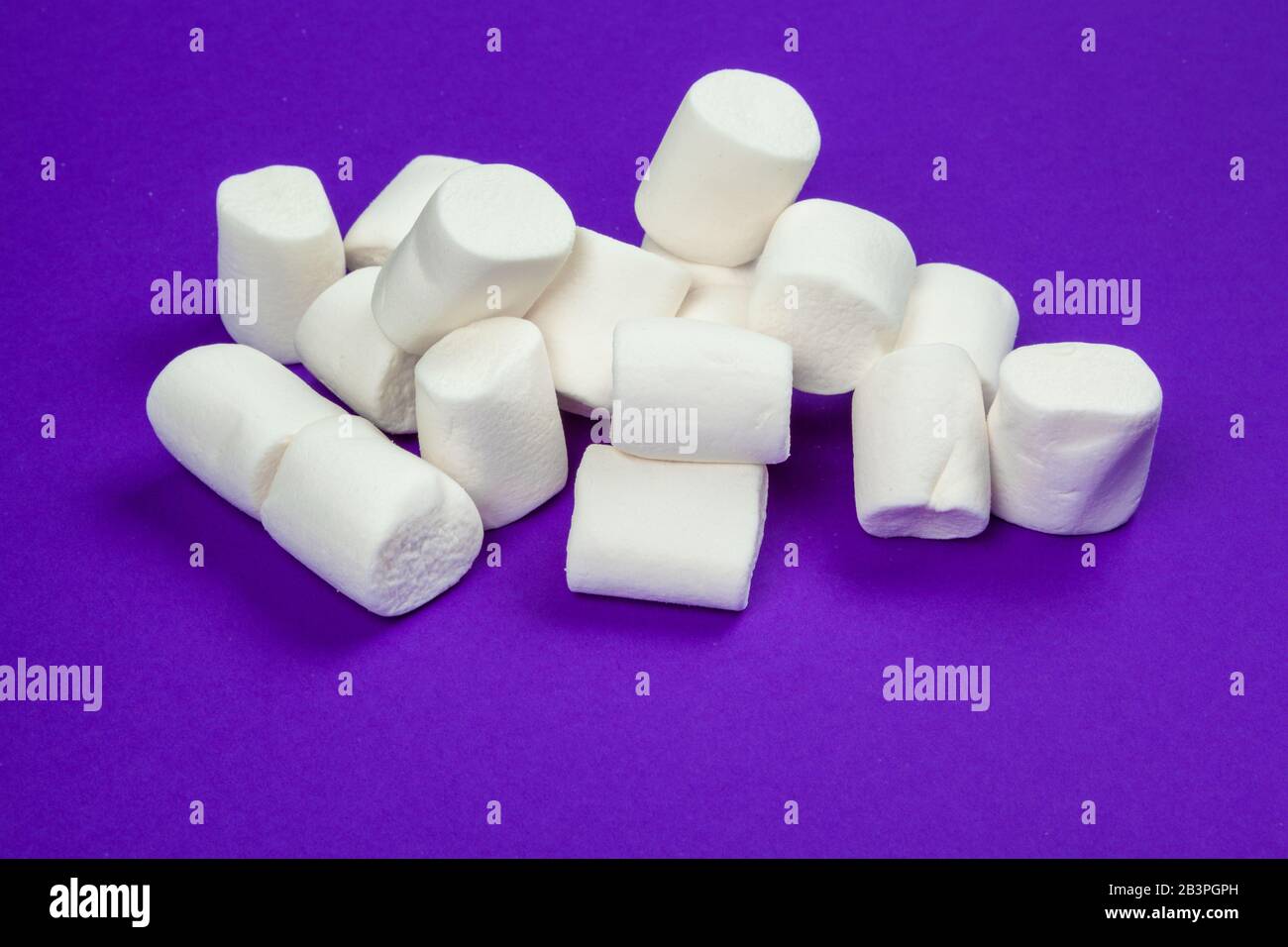 marshmallow laid out on violet paper background Stock Photo - Alamy