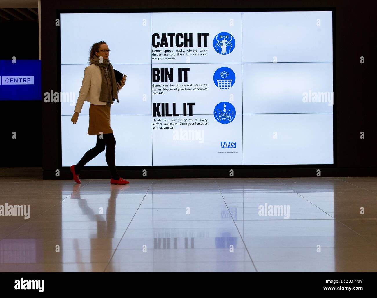 Woman walks past an nhs warning sign hi-res stock photography and ...