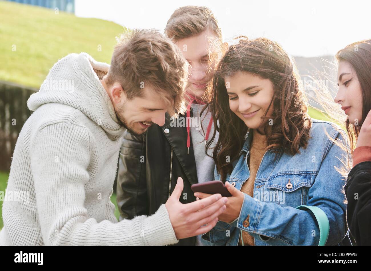 Group of people looking at mobile phone hi-res stock photography and ...