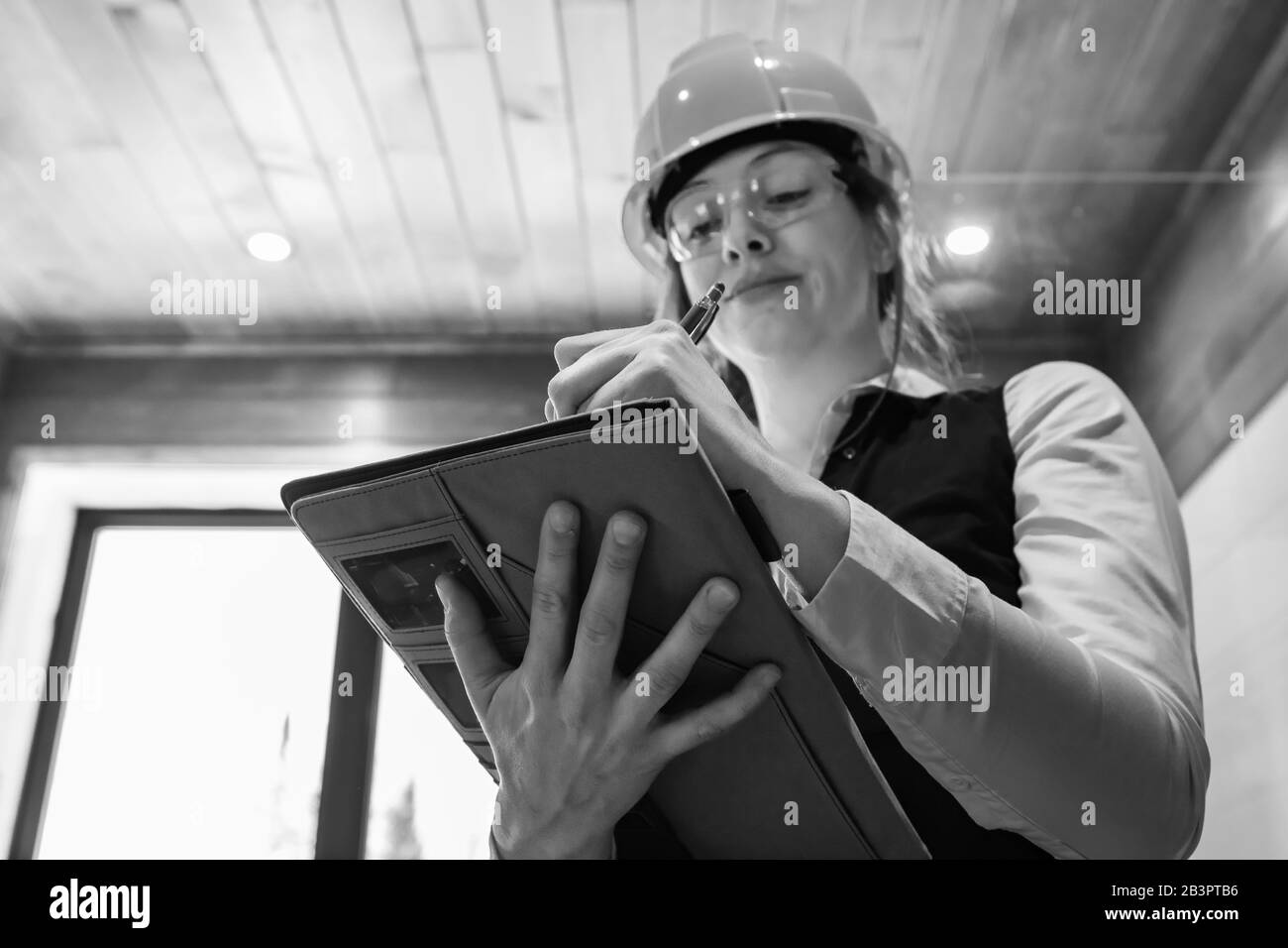 black and white low angle portrait of a female construction inspector ...