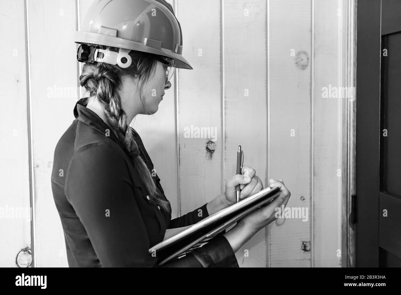 worker woman wears a grey hardhat at work. female construction ...