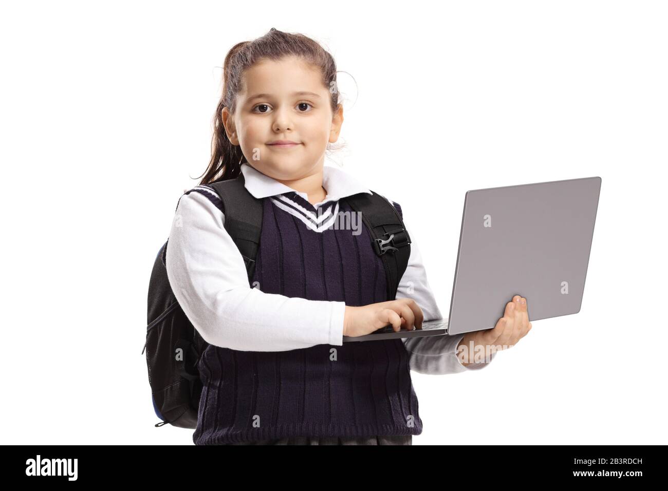 Schoolgirl in a uniform holding a laptop computer and posing isolated ...