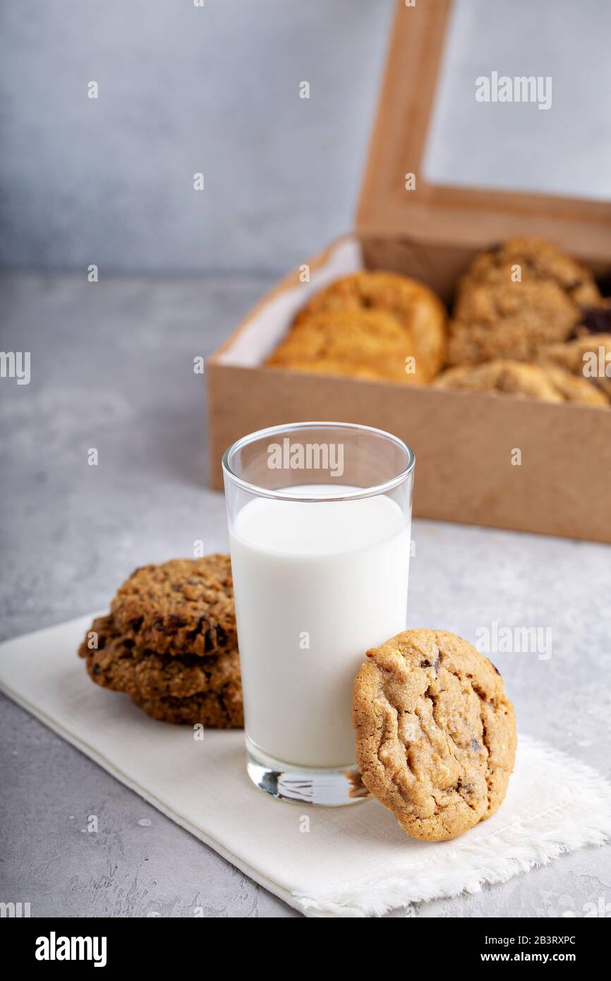 Box of assorted cookies freshly baked and packed to go and a glass of ...