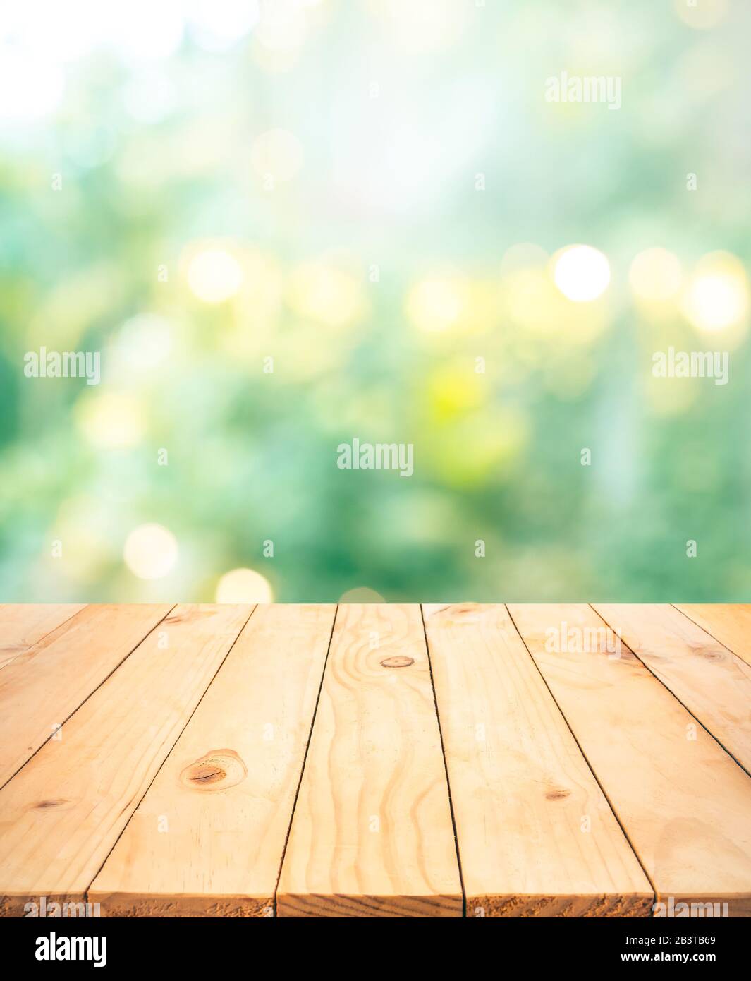 Real wood table top texture on blur leaf tree garden background.For ...