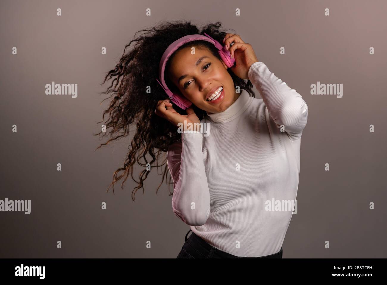 Pretty mixed race girl with curly afro hair having fun, smiling ...