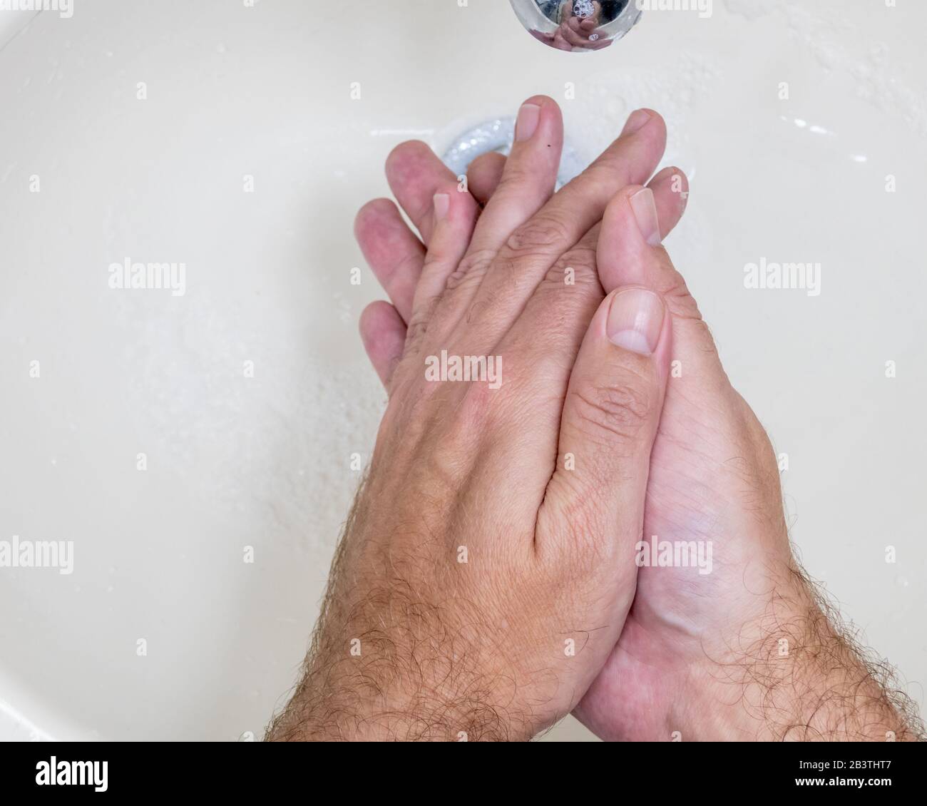 Man washing hands close-up from above, one of several handwashing steps ...