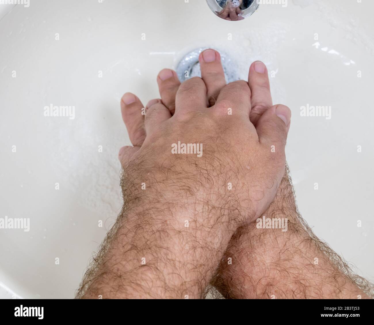 Man washing hands close-up from above, one of several handwashing steps ...
