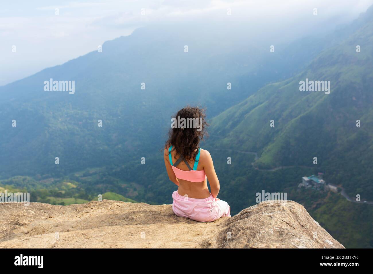 Girl enjoys a mountain view while standing on a cliff Stock Photo - Alamy