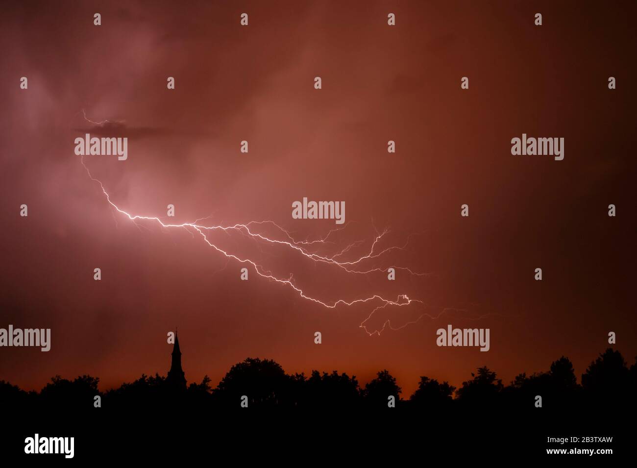 Rain falling and stroke of forked lightning during thunderstorm at ...