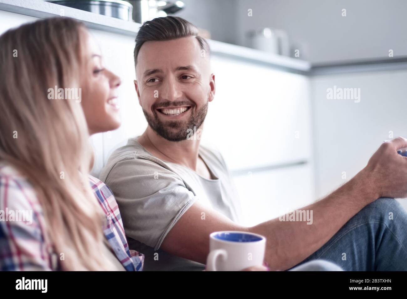 loving couple talking, sitting in the kitchen on the floor Stock Photo ...