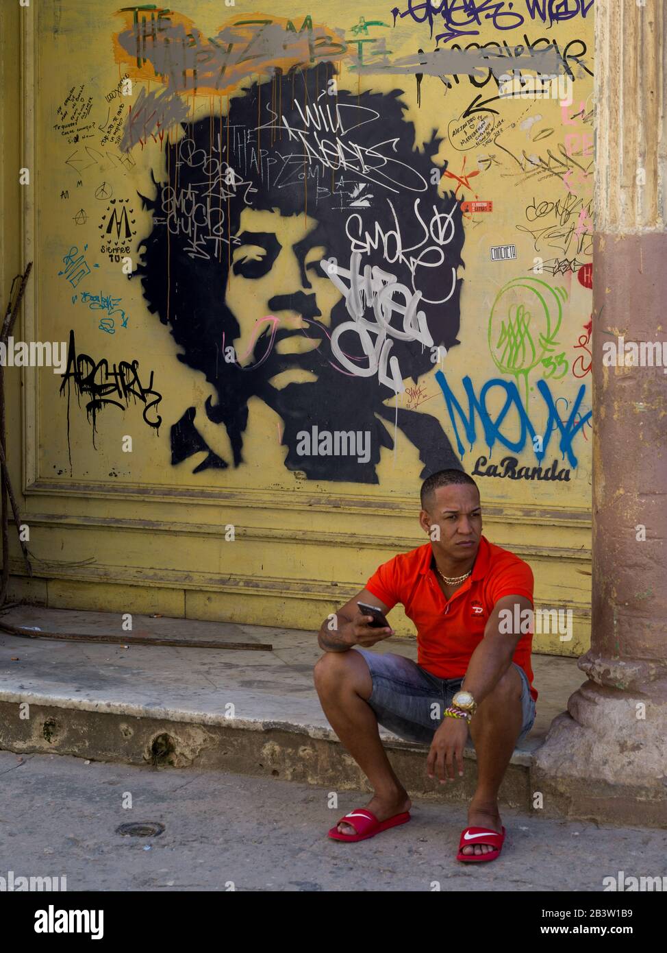 Man sitting on roadside curb using a mobile phone, Havana, Cuba Stock ...