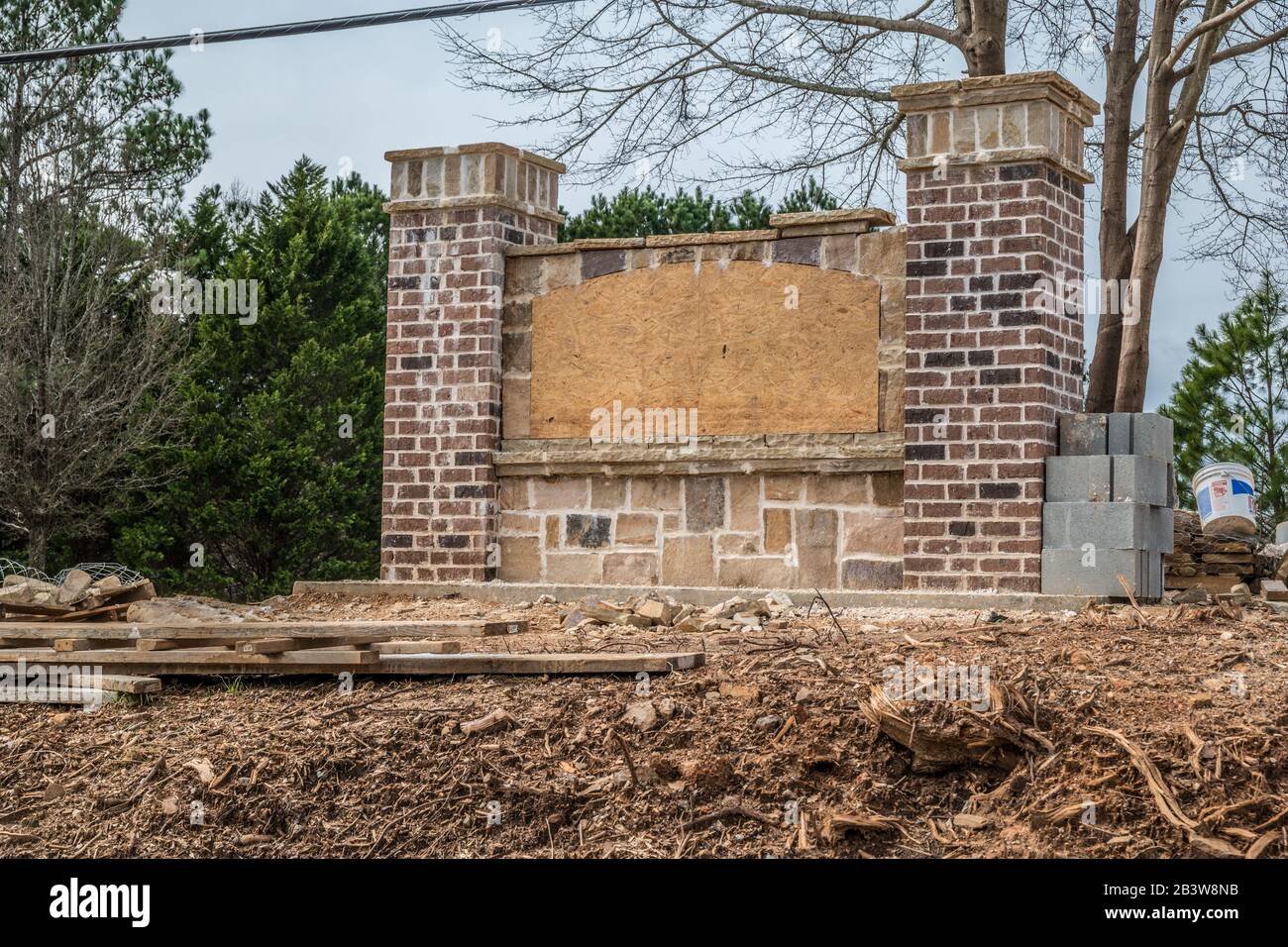 A new community entrance wall being built with brick and stone on a ...