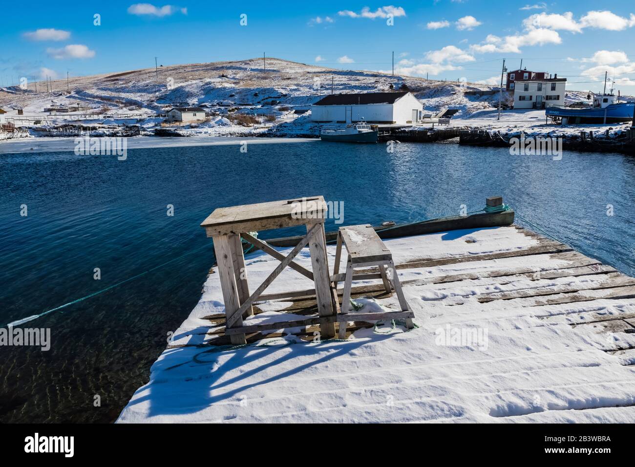 Dock covered with snow in Ferryland, with village distant, Newfoundland ...