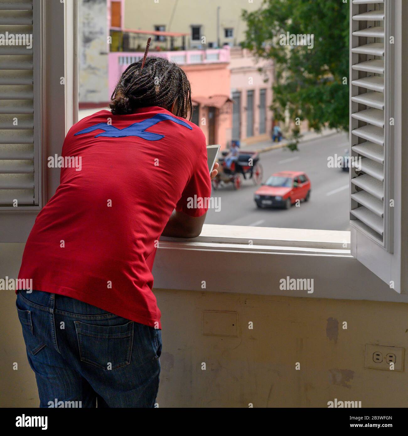 Rear view of a man looking through window, Havana, Cuba Stock Photo - Alamy
