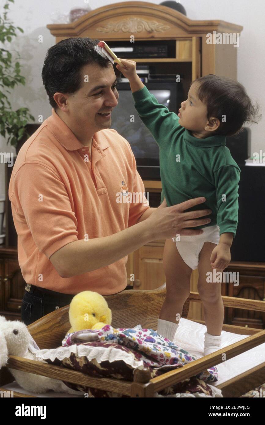 Austin Texas USA, 1995: Hispanic father dresses his Filipino-American ...