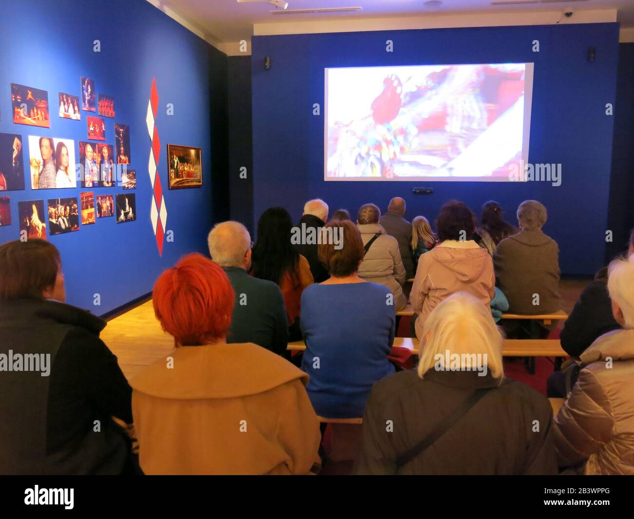 An audience watches the circus performers in a video presentation as ...