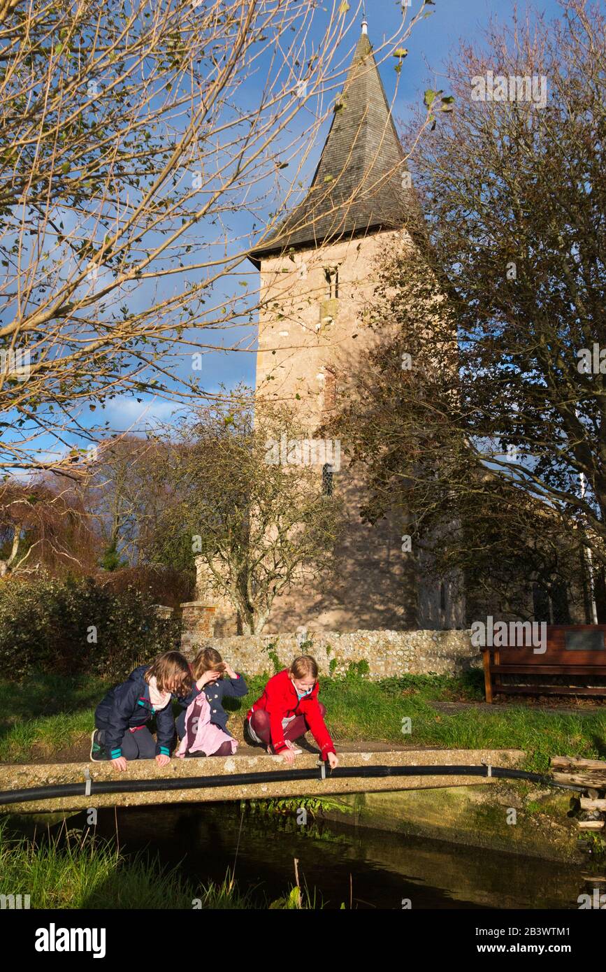 Three young children kids play in the brook stream outside the tower of ...