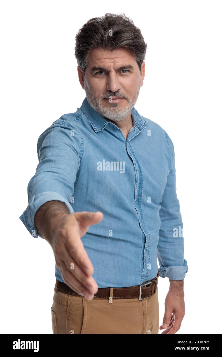 Confident casual man reaching for a handshake while standing on white ...