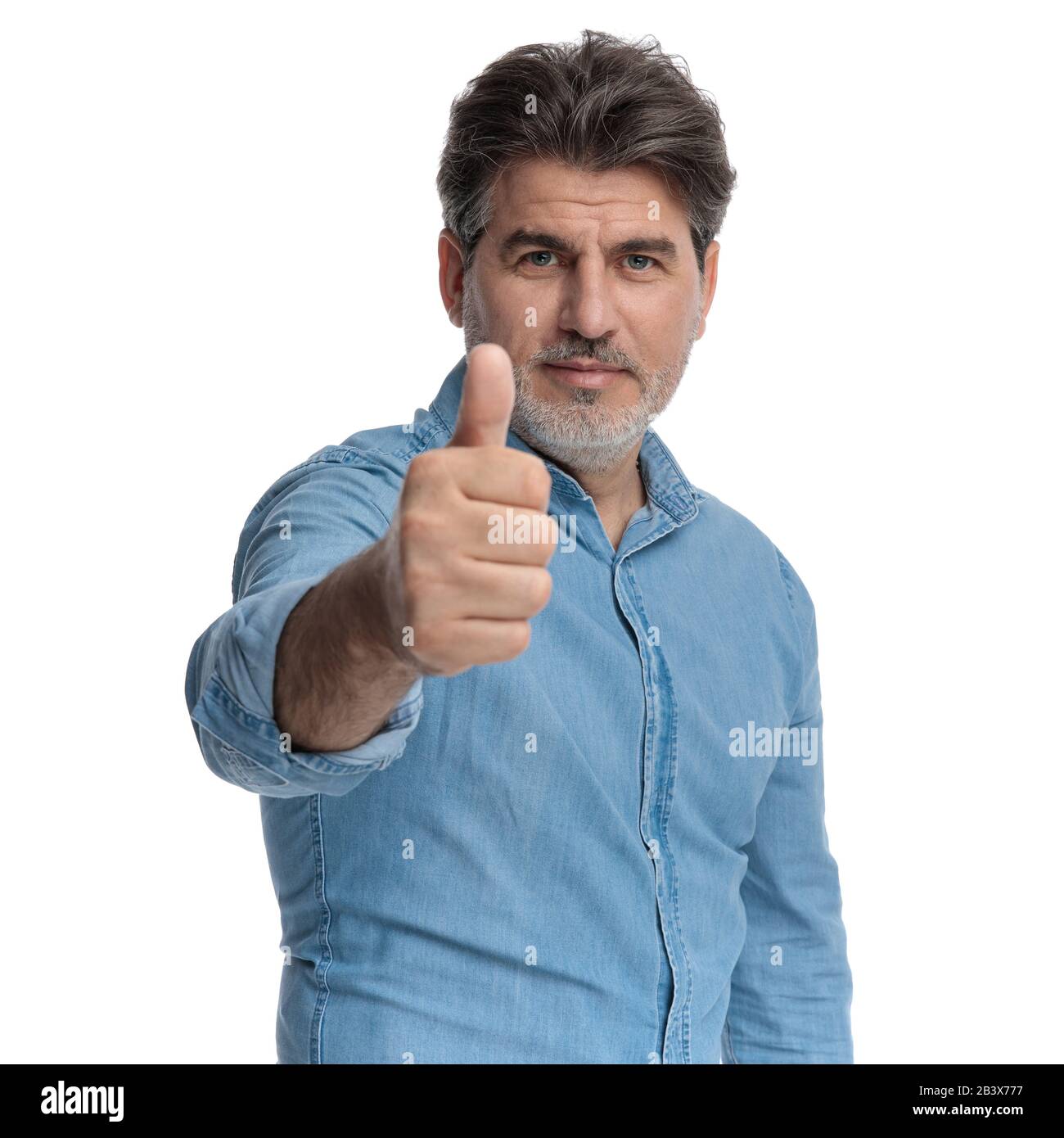 Positive casual man giving a thumbs up and smiling while standing on ...