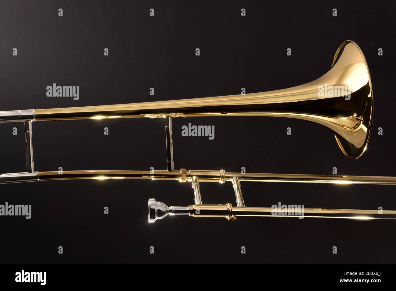 Golden trombone close-up with dark background. Side view. Horizontal ...