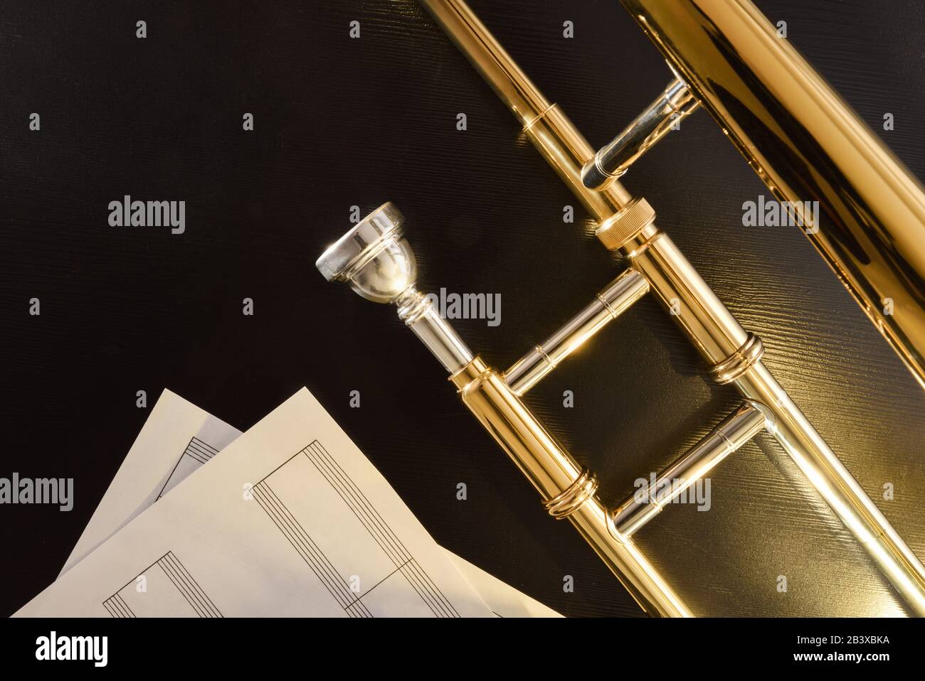 Detail of mouthpiece and trombone braces on black wooden table and ...